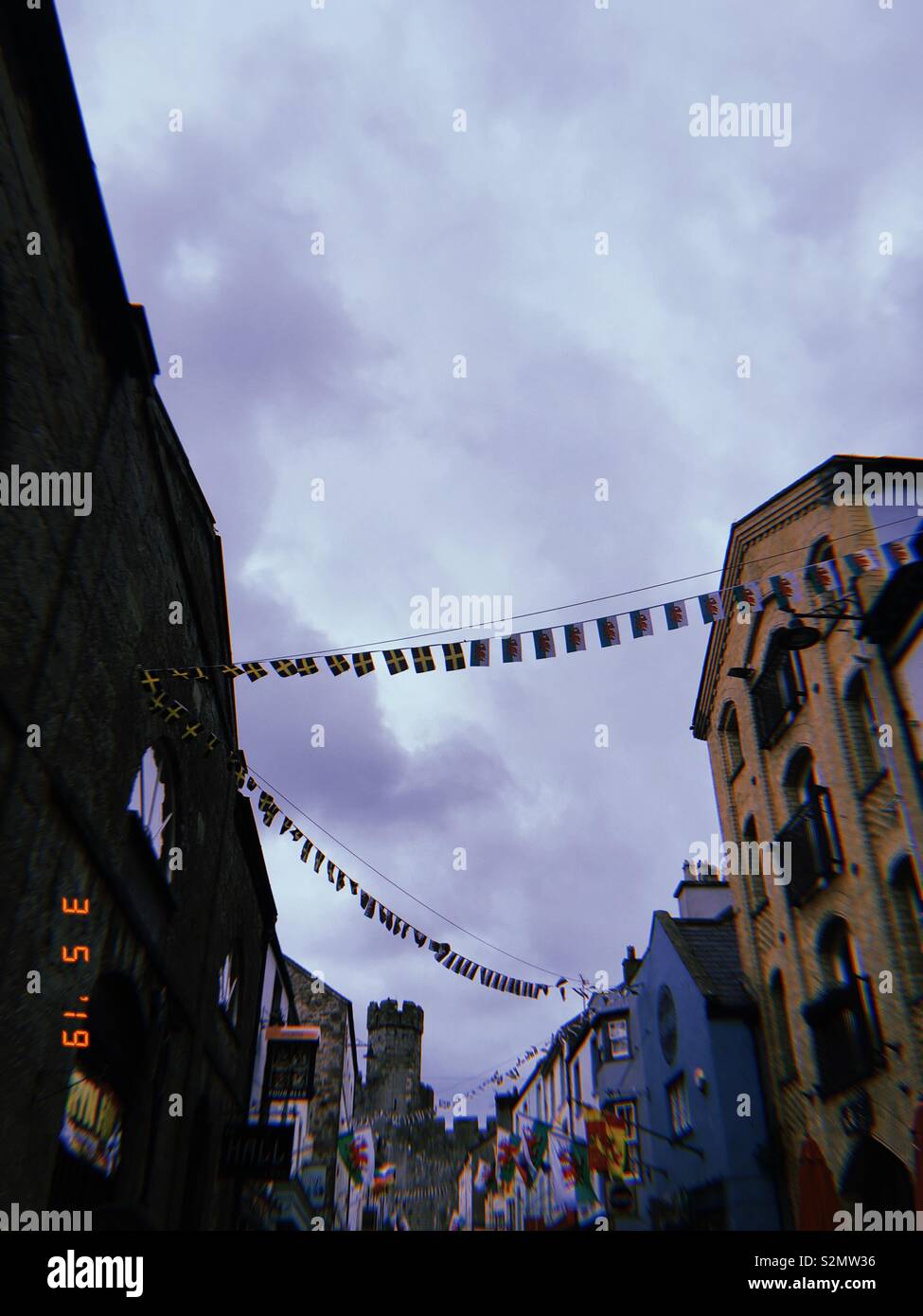 A quiet high street in Wales with flags of counties lining the ...