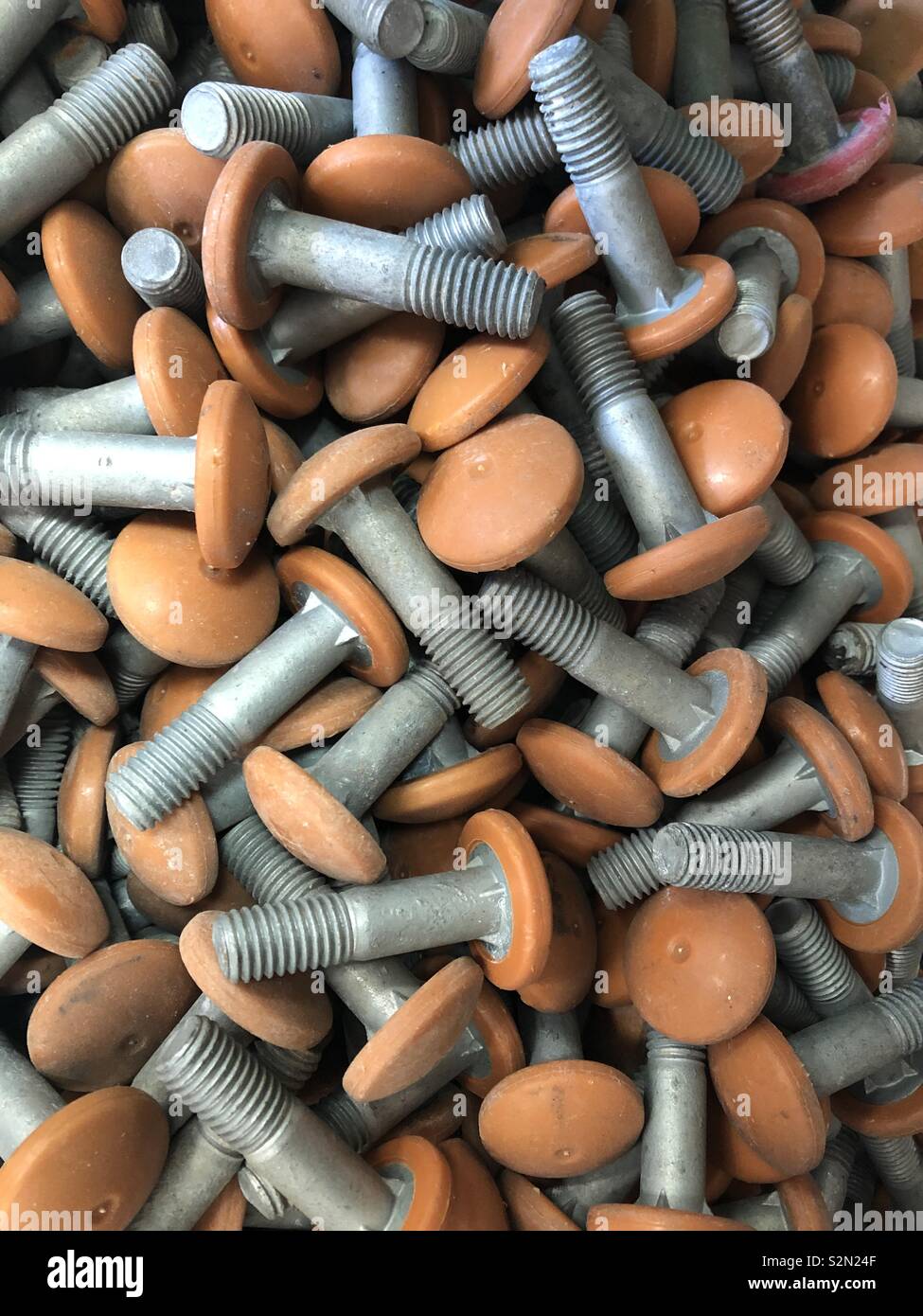 Orange plastic capped bolts Stock Photo - Alamy