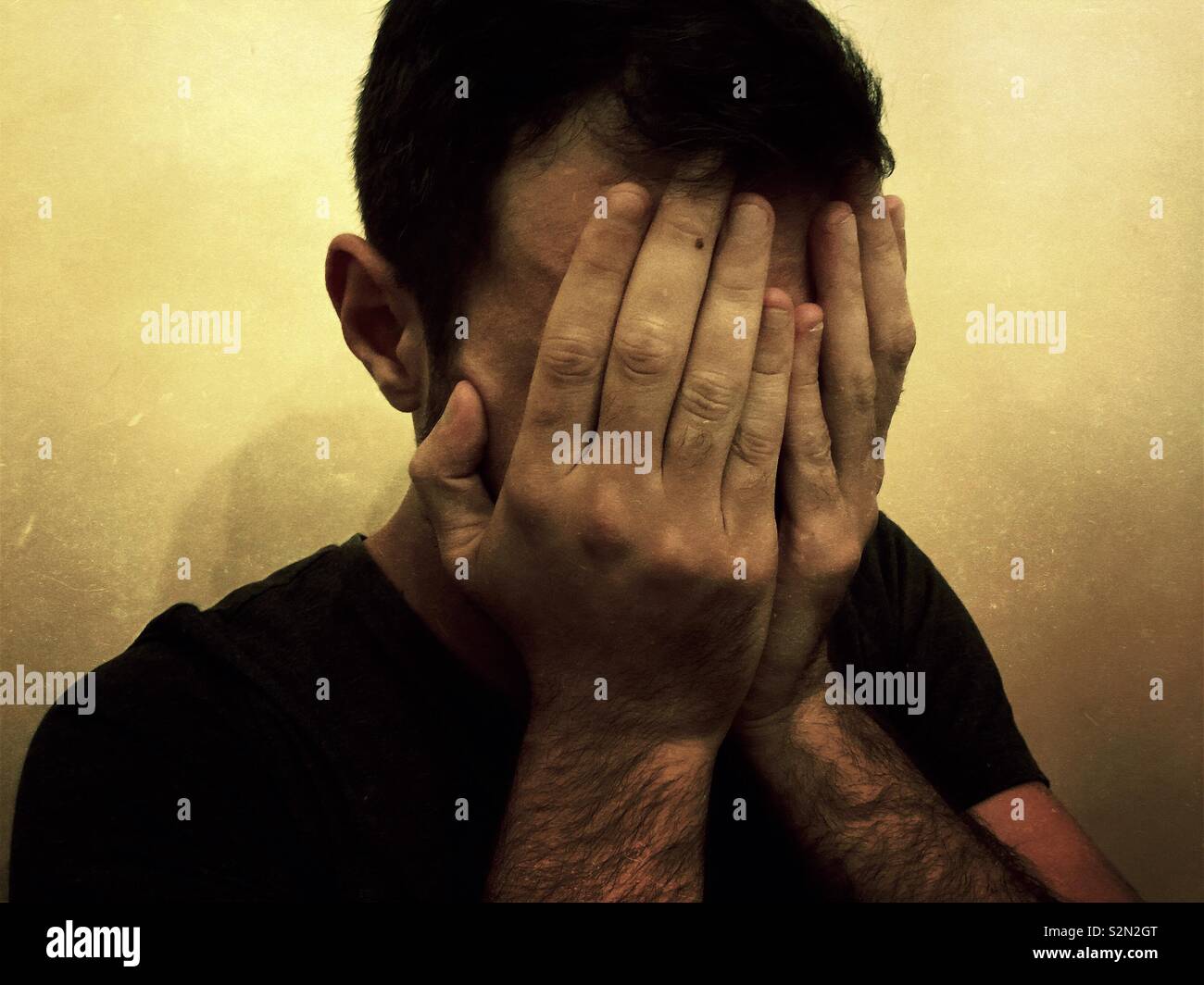 Depressed man hiding face with hands Stock Photo - Alamy