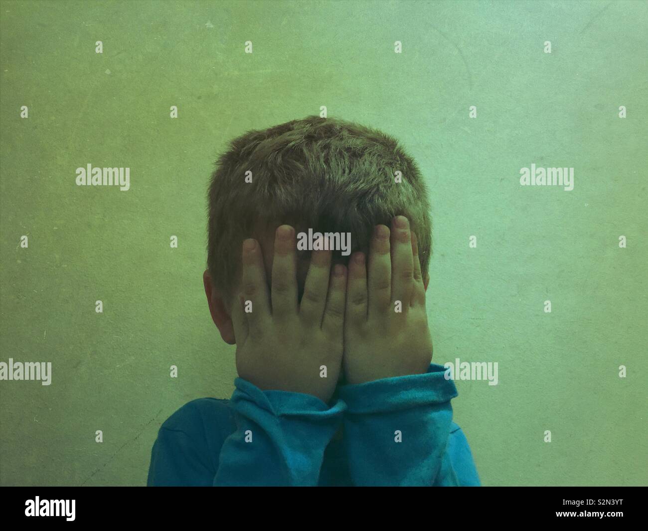 Sad little boy hiding face with hands Stock Photo - Alamy