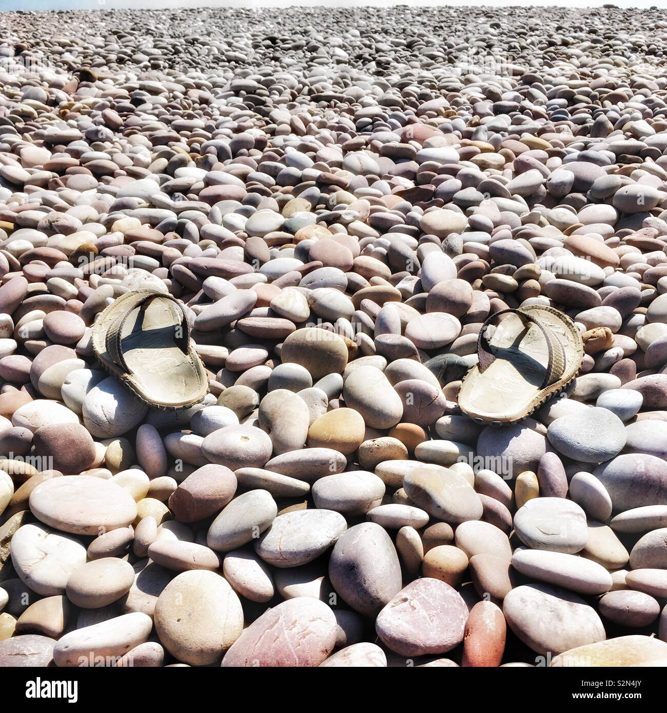 Flip flops on stone beach Stock Photo - Alamy