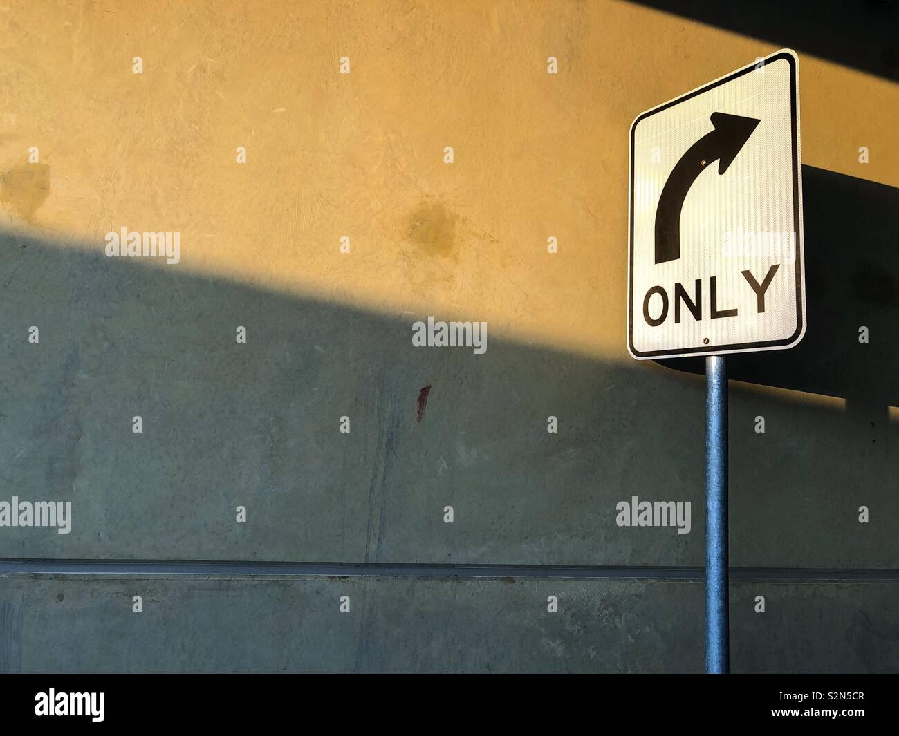 Directional sign with an arrow and the word only Stock Photo - Alamy