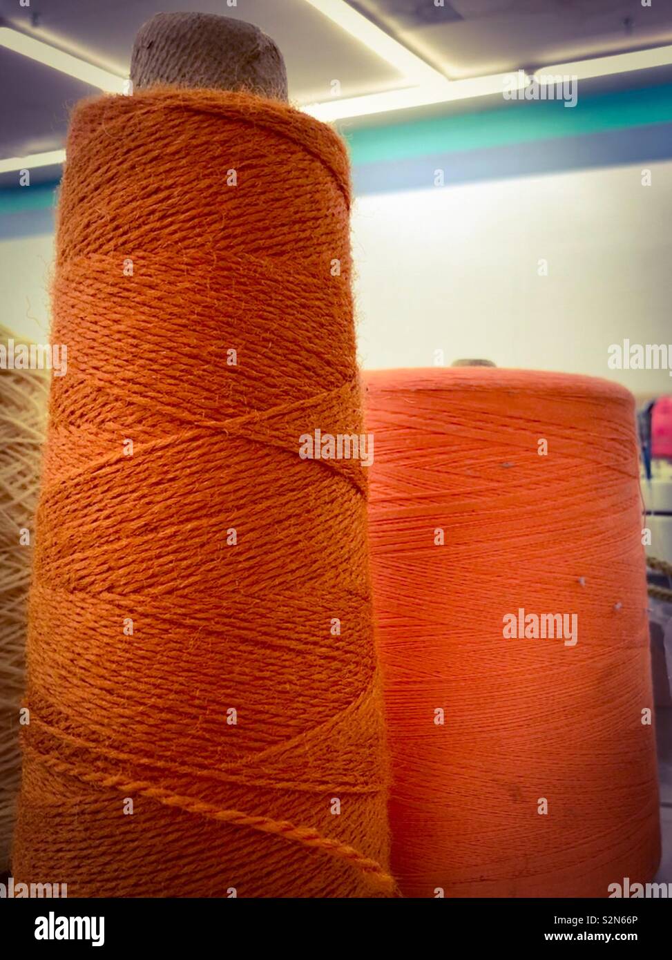 Three different shades and textures of orange yarn on spools for sale ...