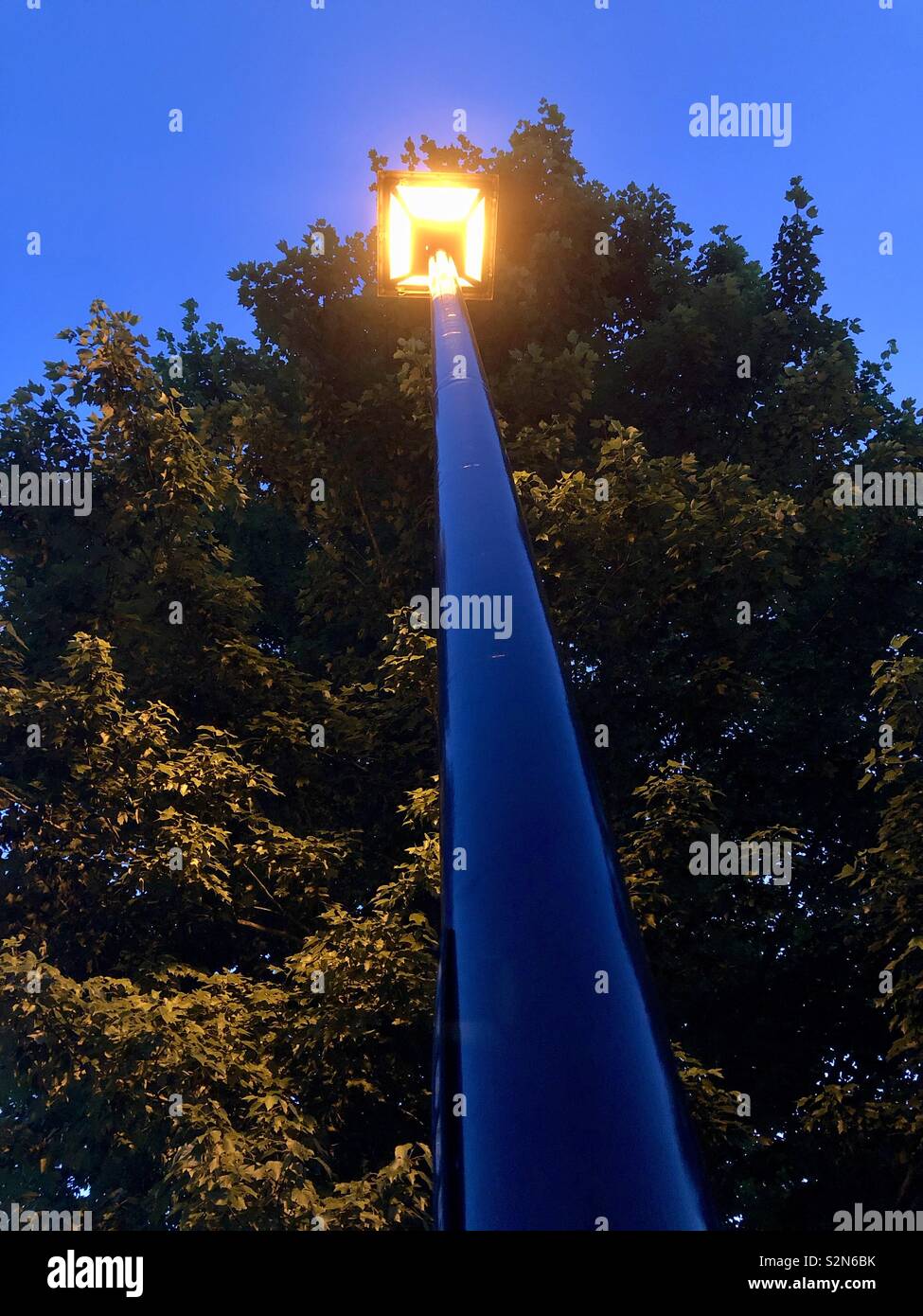 Looking up a light pole reflecting very intense light Stock Photo - Alamy
