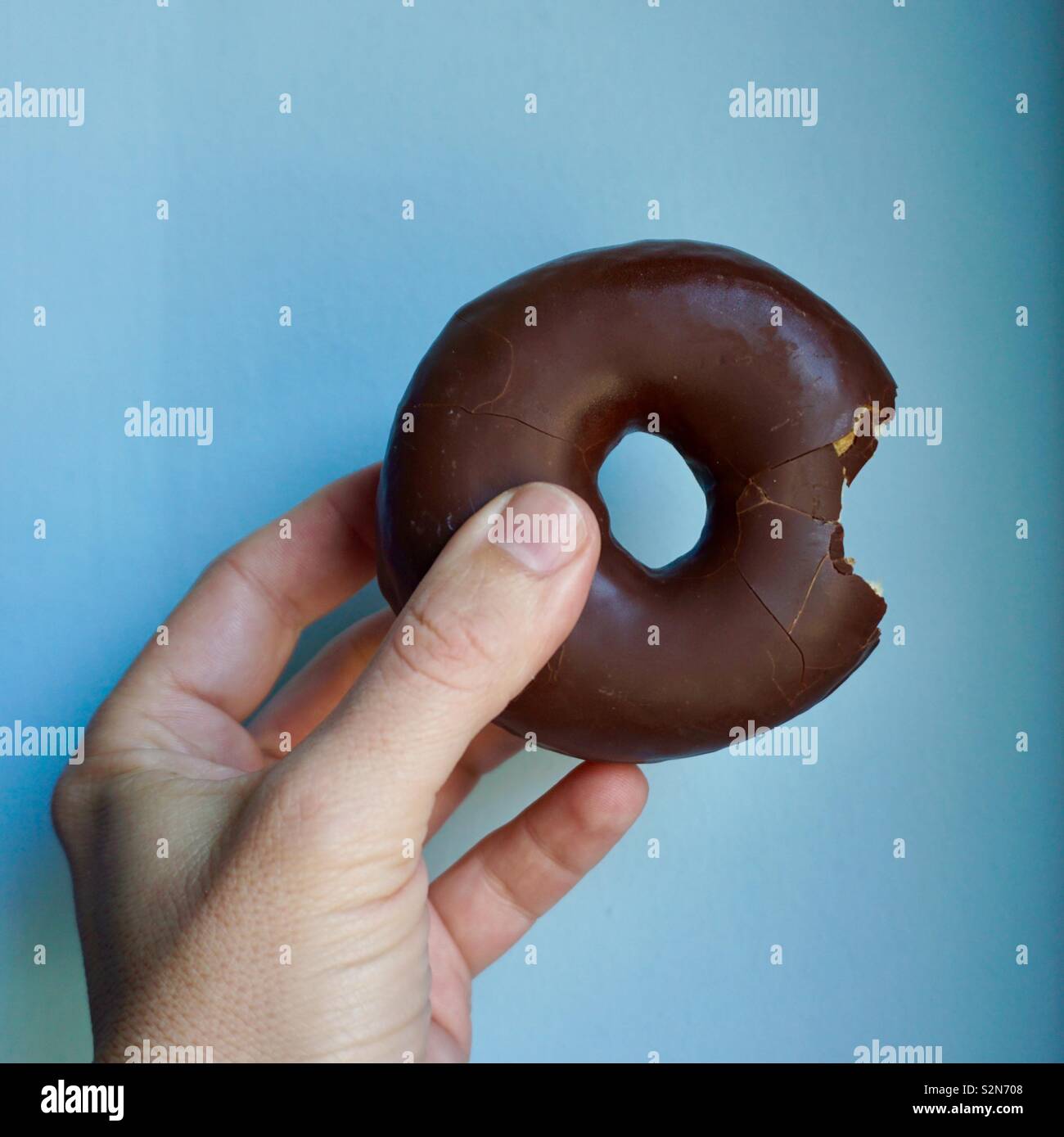hand with chocolate donut Stock Photo - Alamy