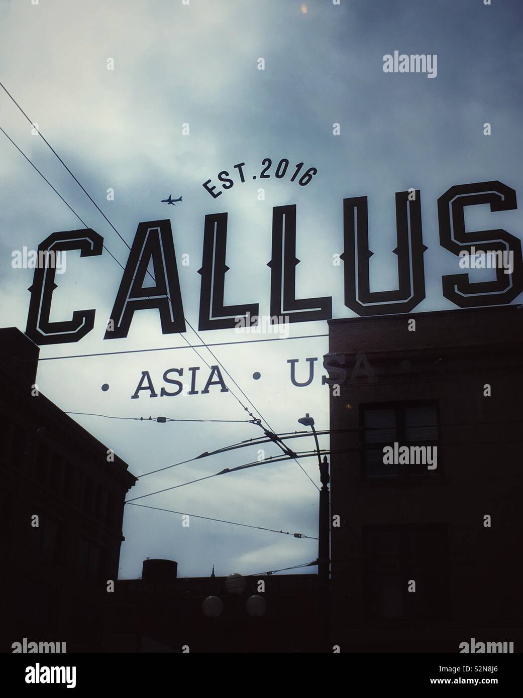 Callus Cafe sign on a window with airplane in the sky. Seattle, WA, USA ...