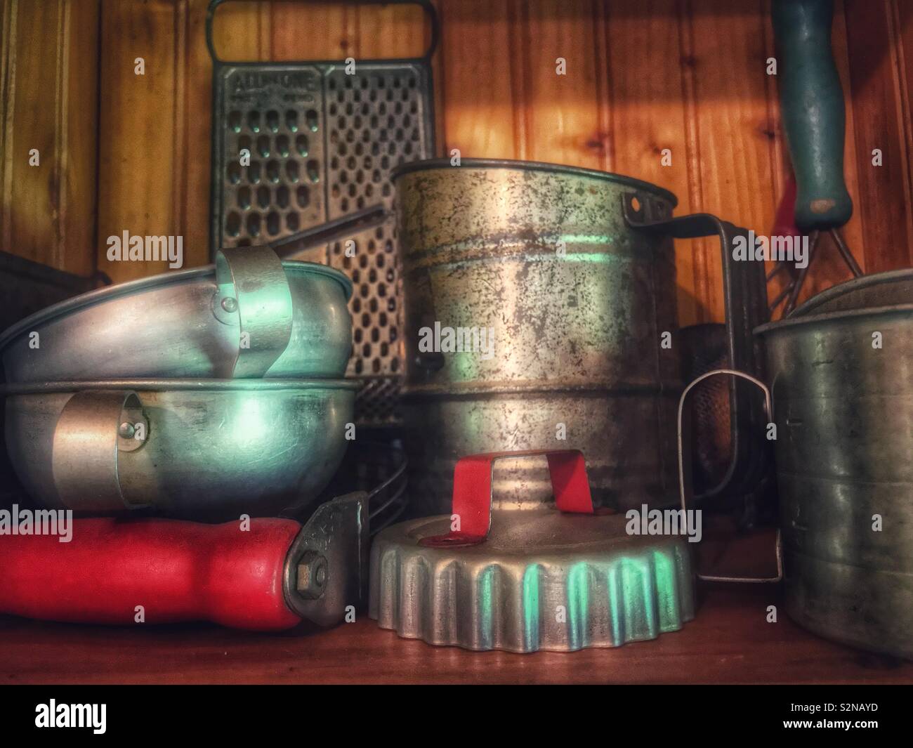 Vintage metal kitchenware on display in wood shelf with pops of red ...