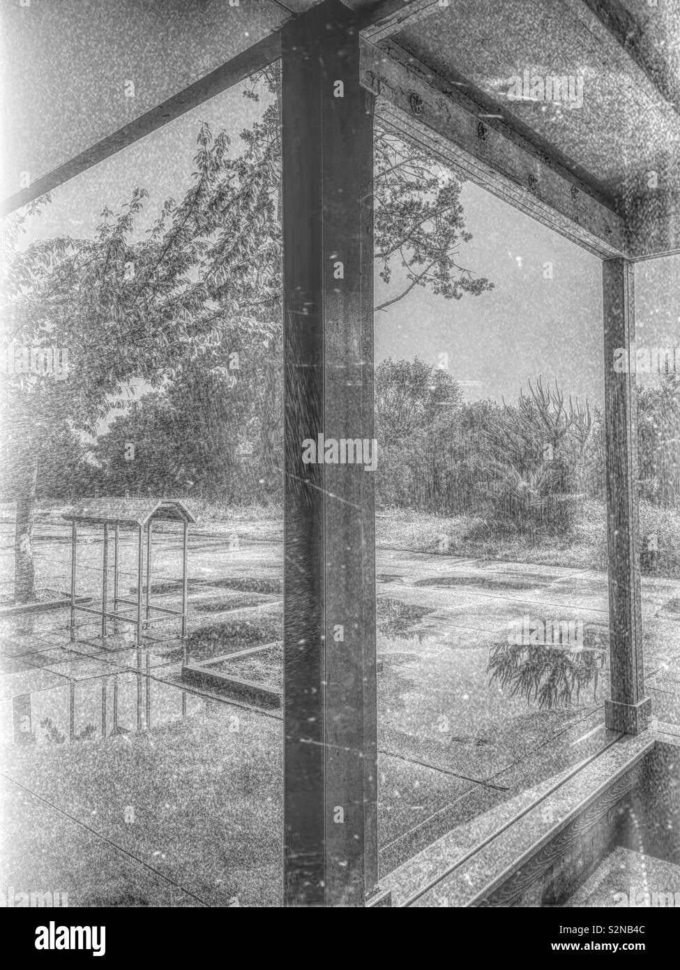 Watching rain in a pavilion in black and white Stock Photo - Alamy