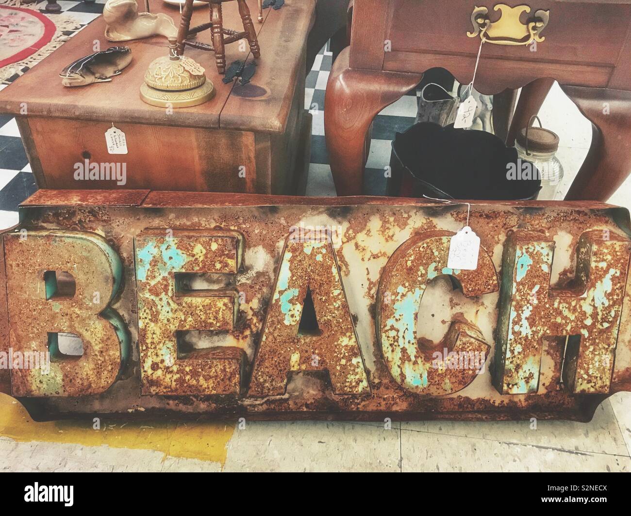 Metal sign covered with rust with the word BEACH in raised letters on ...
