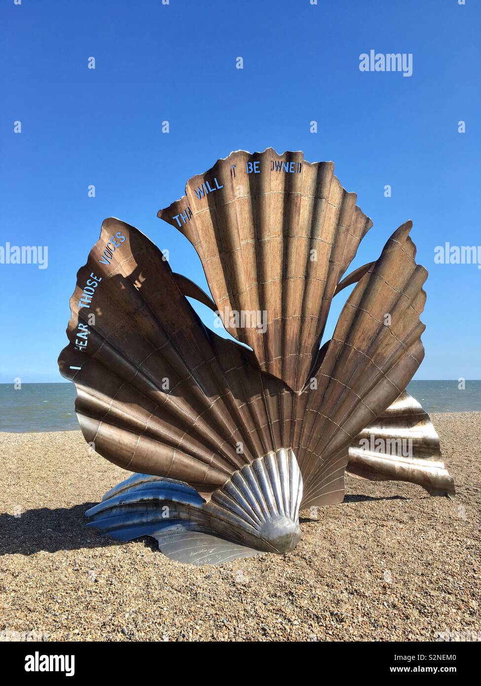 Shell sculpture on beach with pebbles, sea and blue sky Stock Photo - Alamy