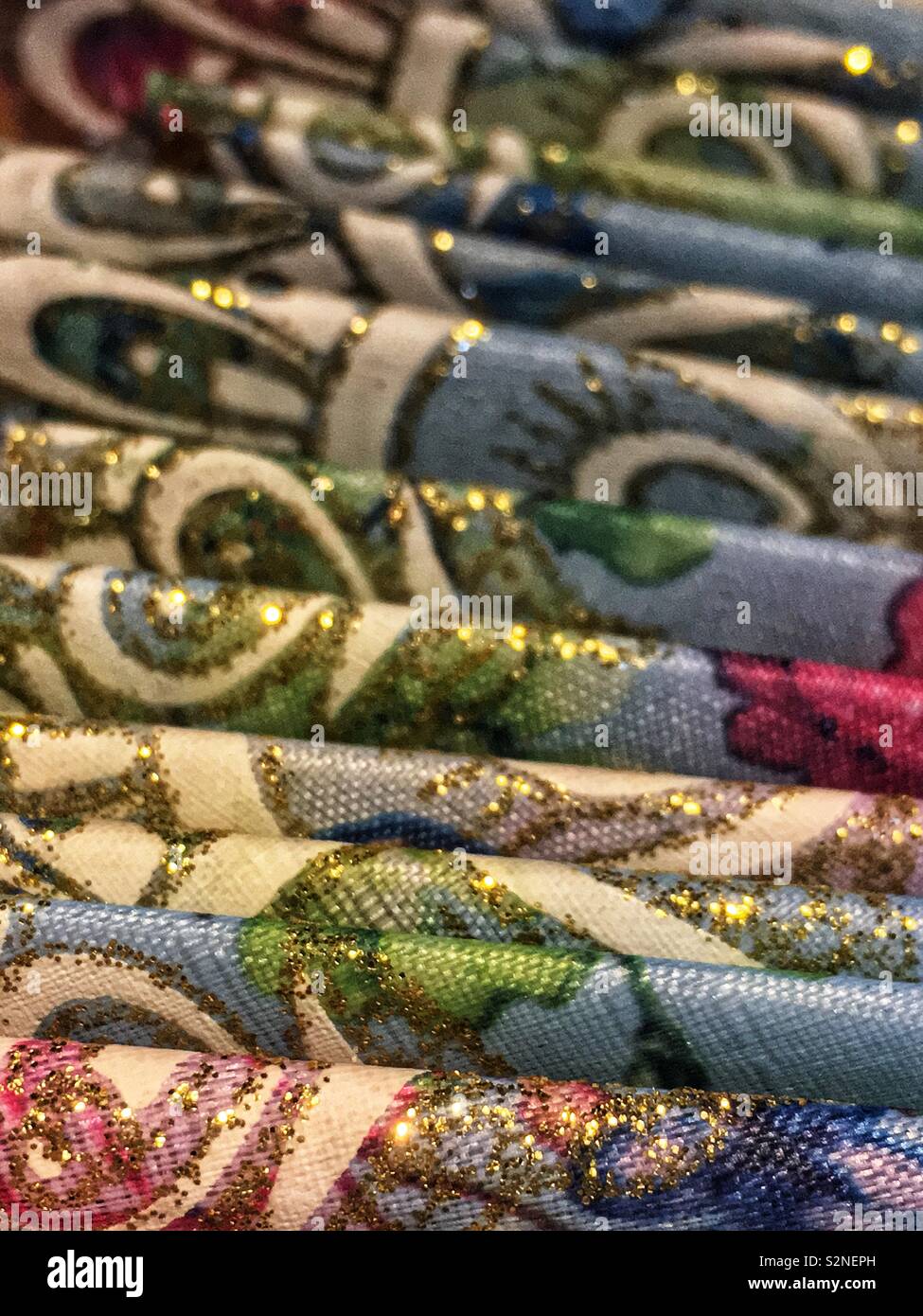 Folded fabric with gold glitter and sparkles and a pink, white, and ...