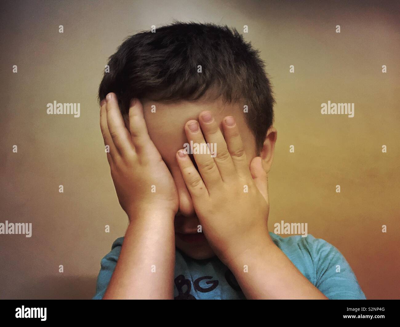 Little boy hiding face with hands Stock Photo - Alamy