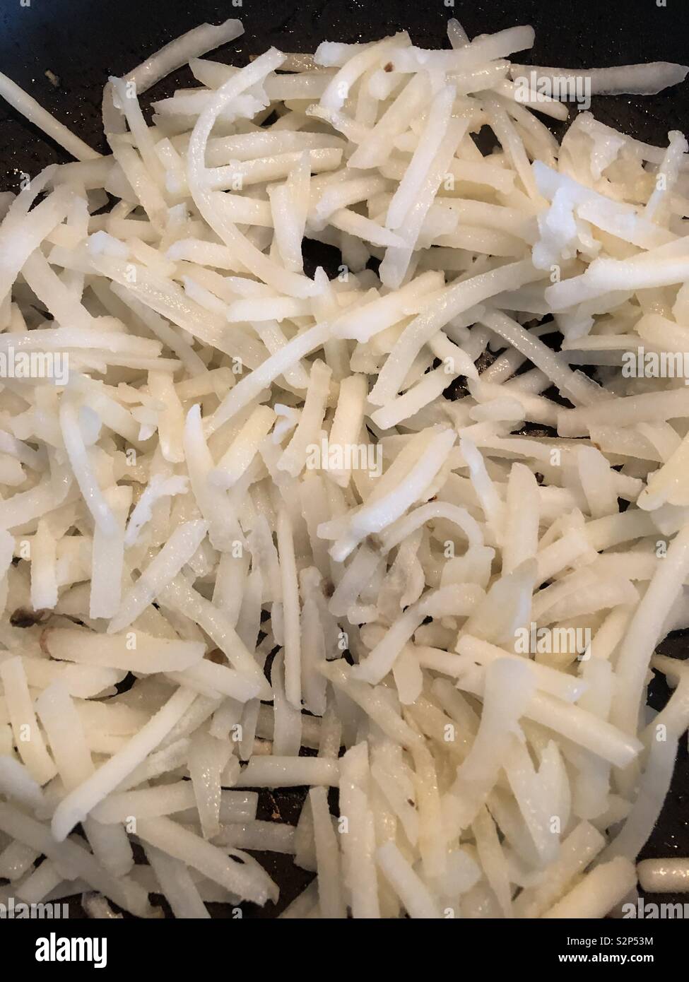 Shredded potatoes cooking in a pan - abstract Stock Photo - Alamy