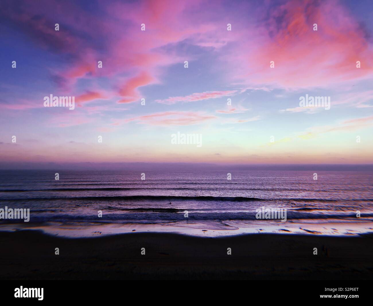 Sunset over water at beach Stock Photo - Alamy