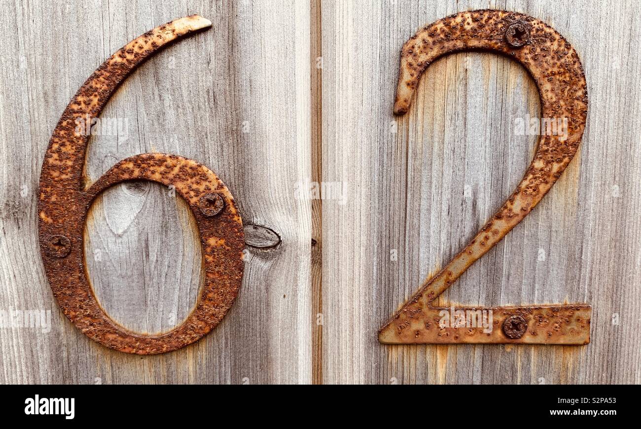Rusty metal number sixty two on wooden door Stock Photo - Alamy