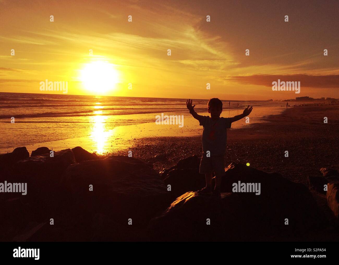 Boy on beach enjoying the sunset Stock Photo - Alamy