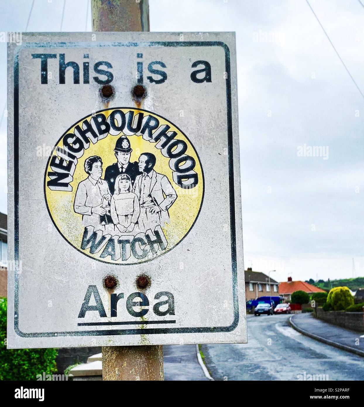 Neighbourhood watch area sign next to road with houses and cars in ...