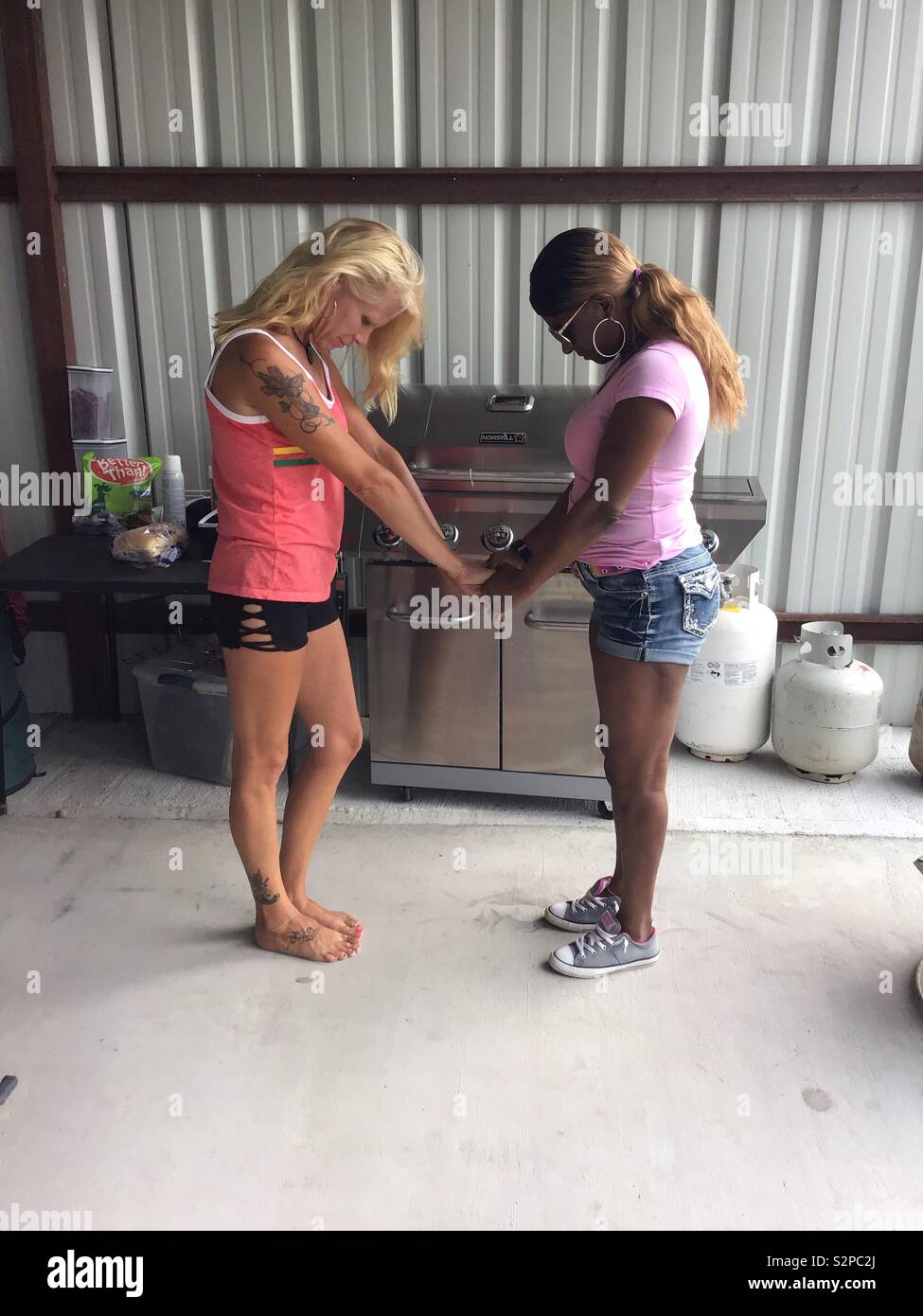 Two women praying together hi-res stock photography and images - Alamy