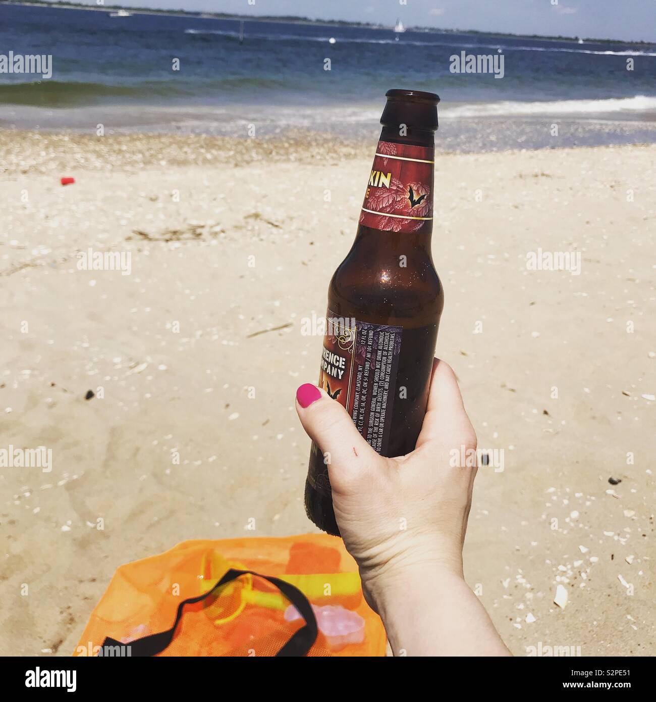 Woman holding beer bottle at the beach Stock Photo - Alamy