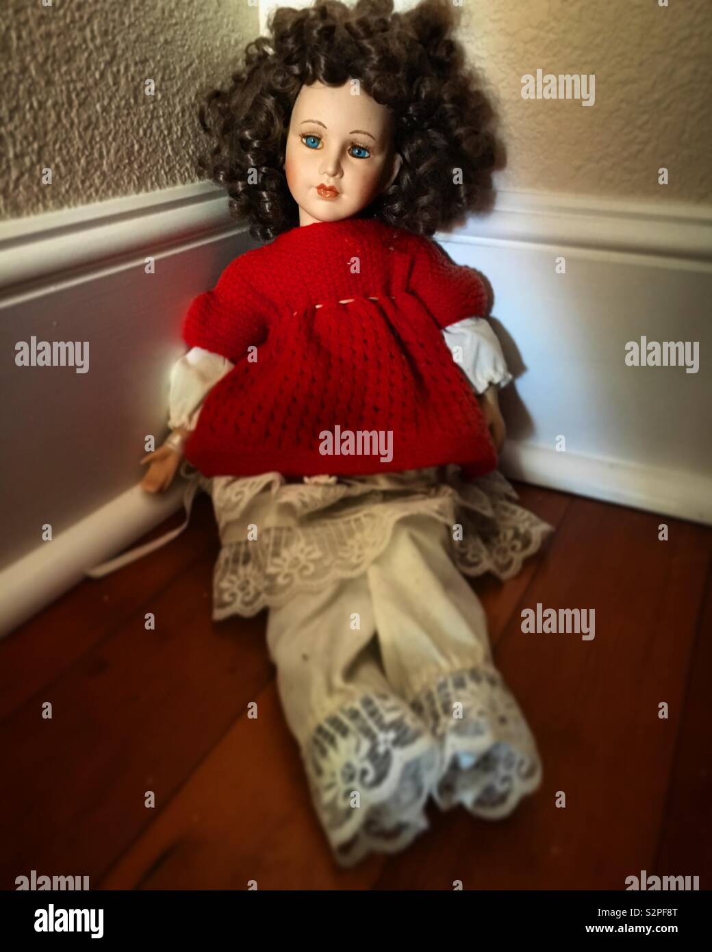 Doll in the corner of the bedroom Stock Photo - Alamy