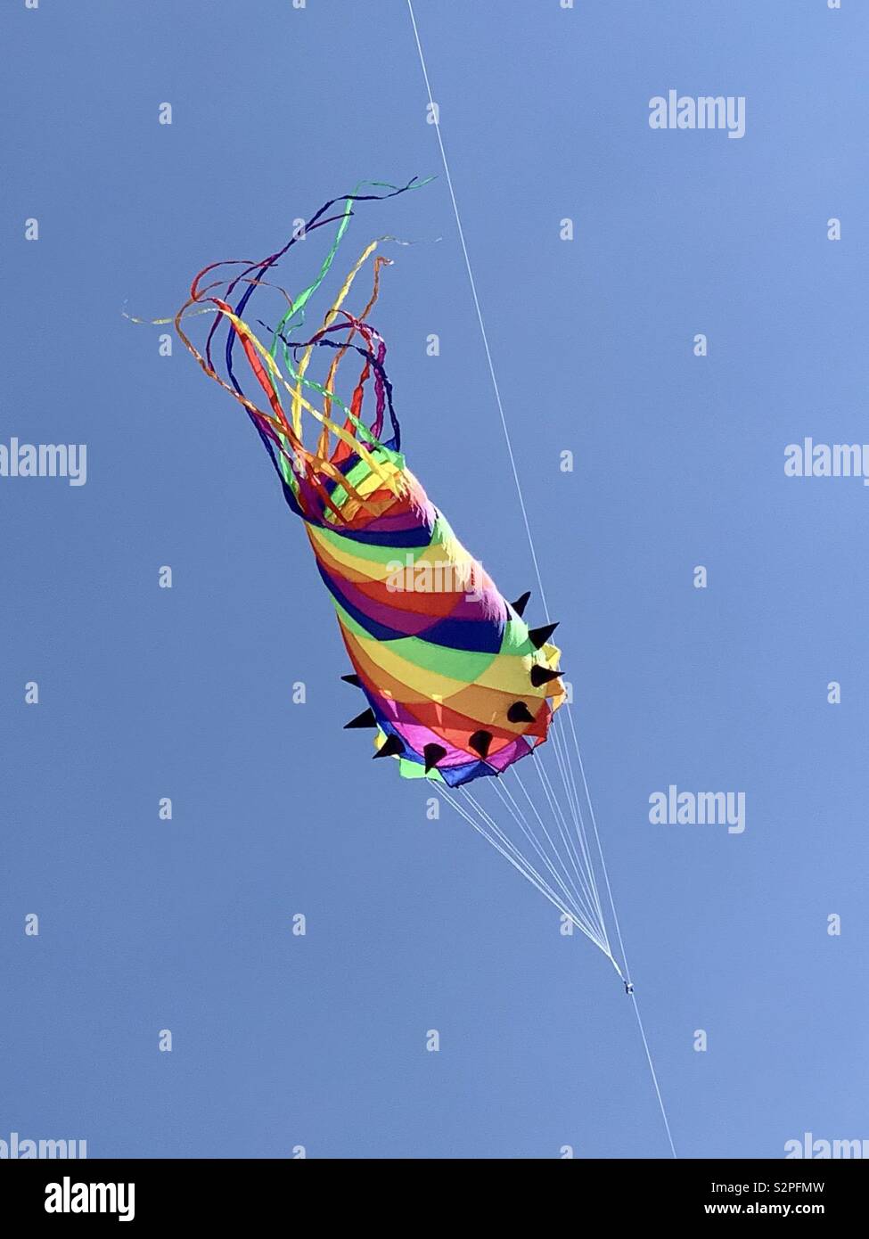 Let’s fly a kite. Colorful kite flying in the air with blue skies Stock ...