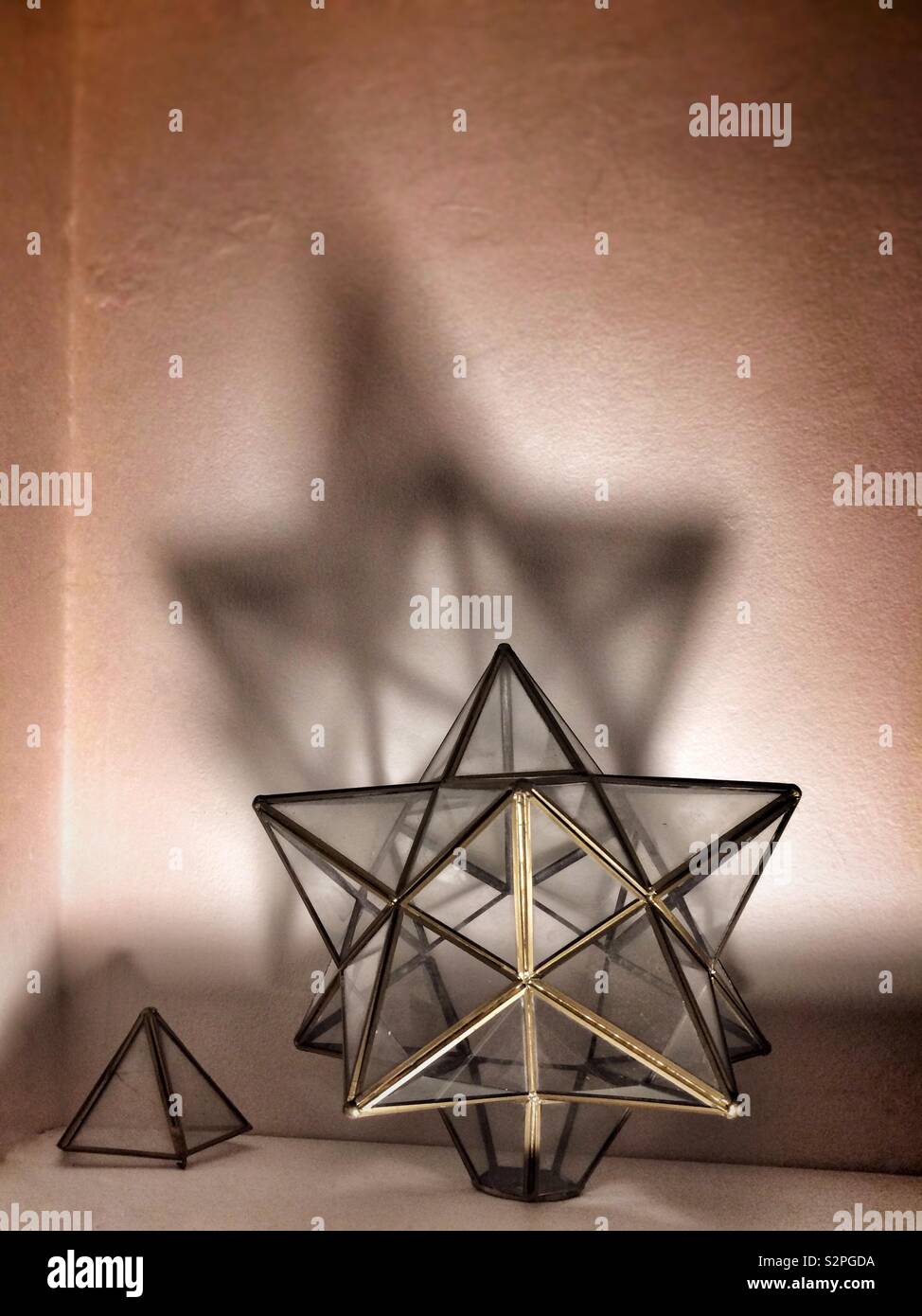 Geometry and shadows - star and triangle shaped glass ornaments on a ...