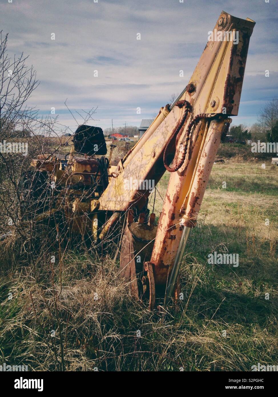 Rusted yellow backhoe in farm field, full sunlight Stock Photo - Alamy