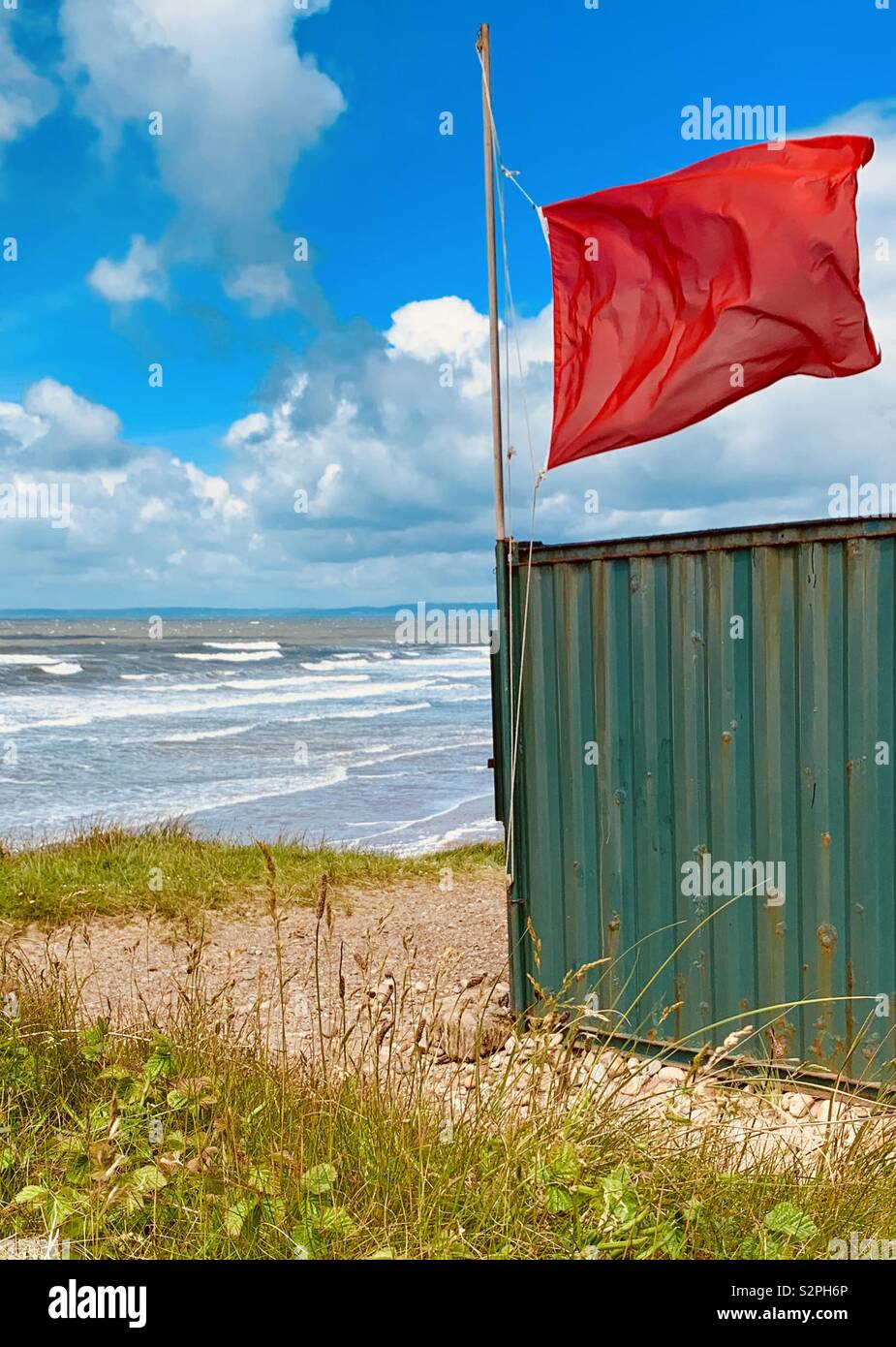 Red flag flying in strong wind on lifeguard station at Sker beach South ...