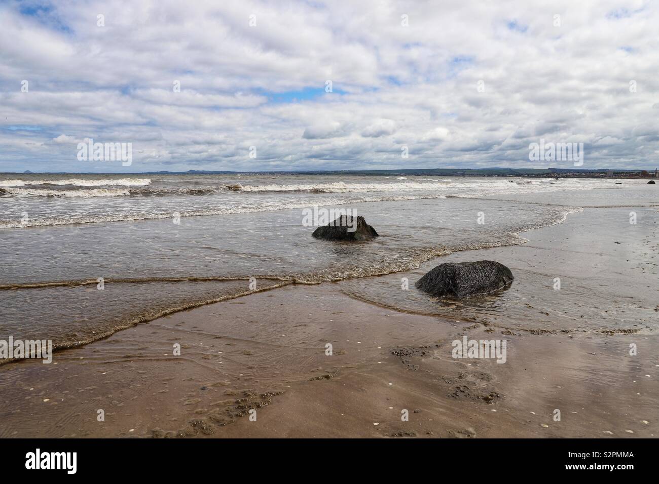 Rocks exposed by receding tide on overcast day Stock Photo - Alamy