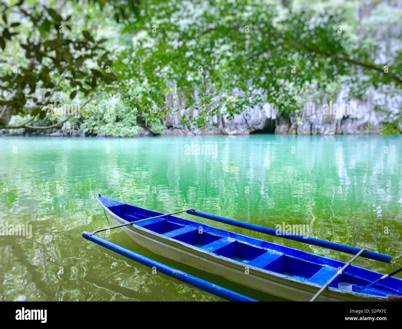 Small blue boat in a river Stock Photo - Alamy