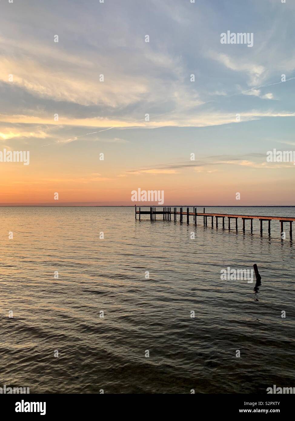 Beautiful sunset over bay water and pier Stock Photo - Alamy