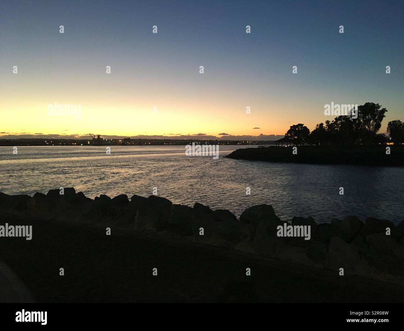 Sun setting by the water Stock Photo - Alamy