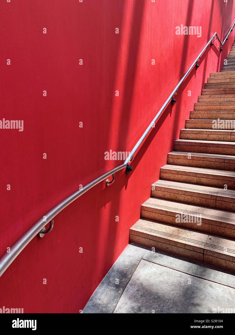 Red wall with stainless steel railing and stairs going up Stock Photo ...