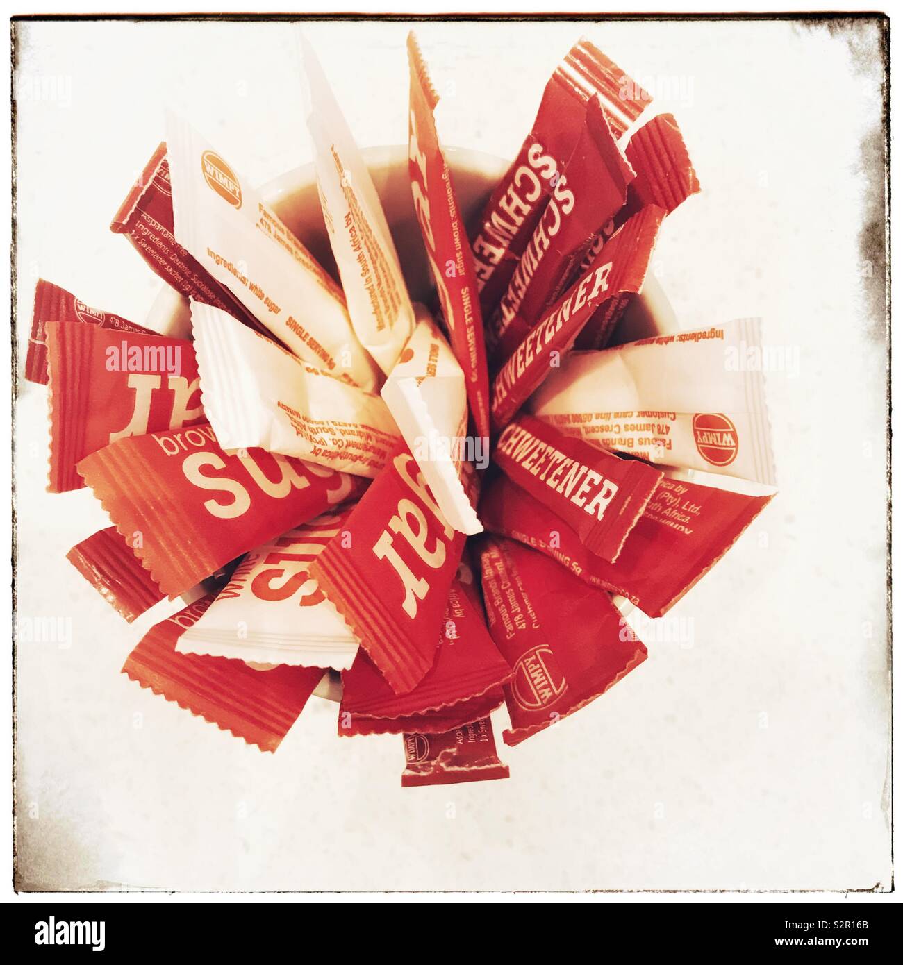 Tubes of sugar in cup Stock Photo - Alamy