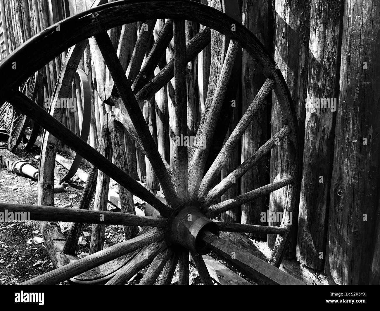 Antique rock bucket and wagon wheel Black and White Stock Photos ...