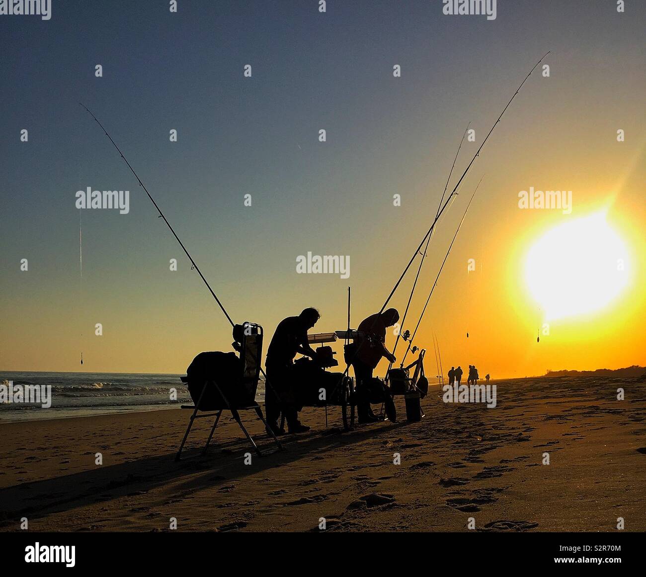 Sunset beach fishing Stock Photo - Alamy