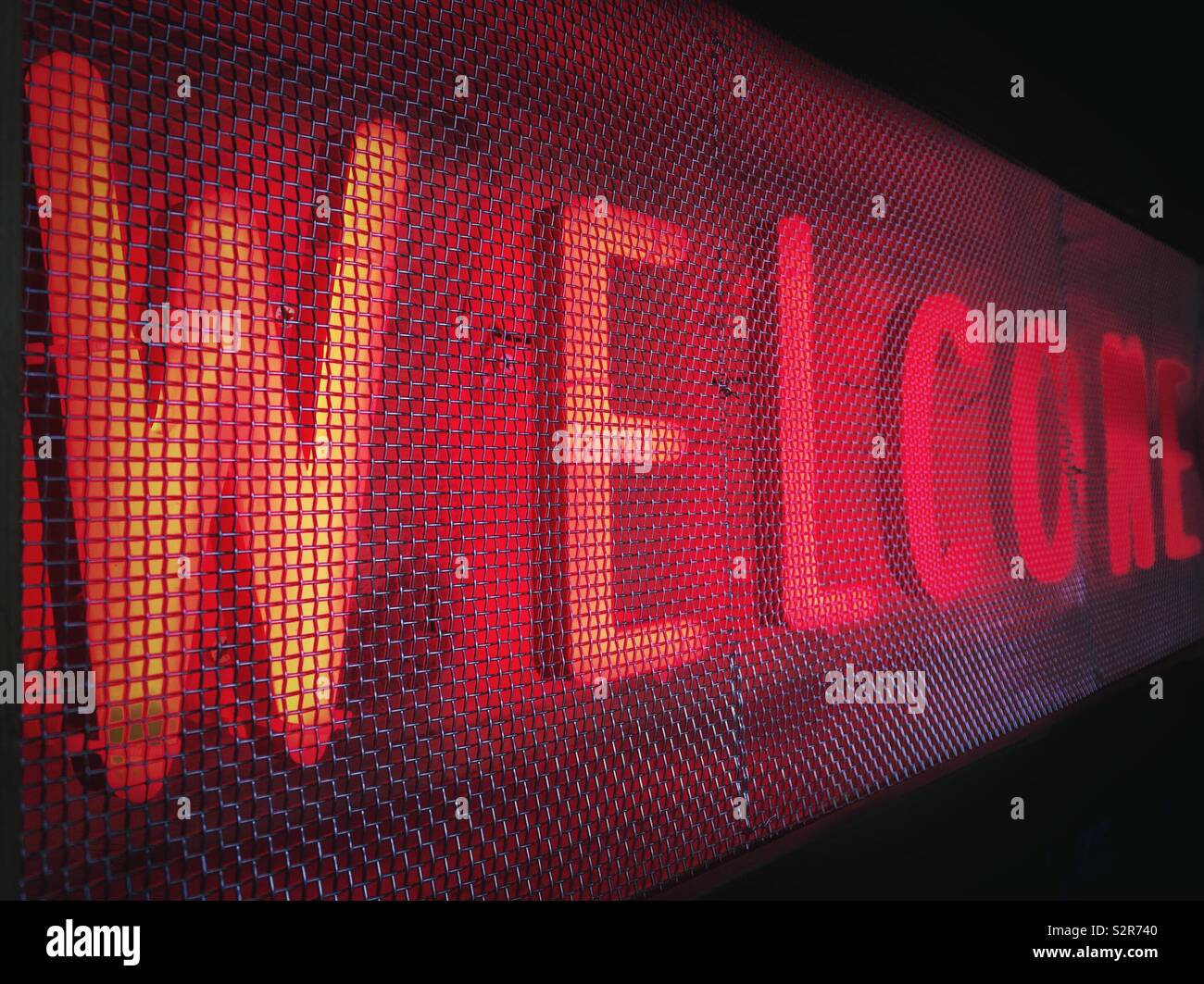Neon welcome sign in red with mesh Stock Photo - Alamy