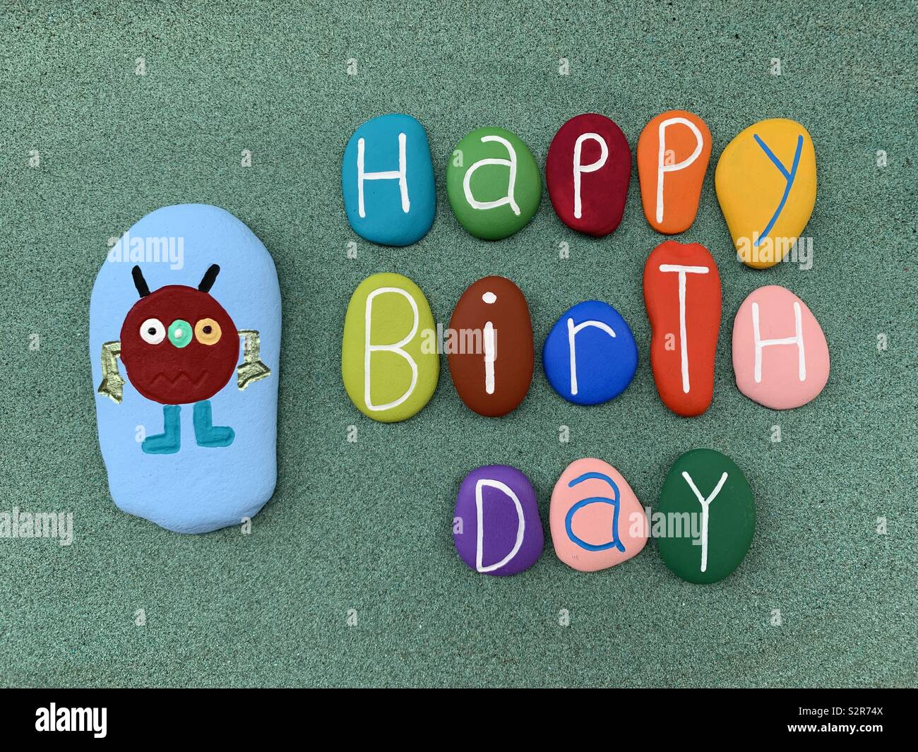 Happy Birthday with creative and colored stones over green sand Stock ...