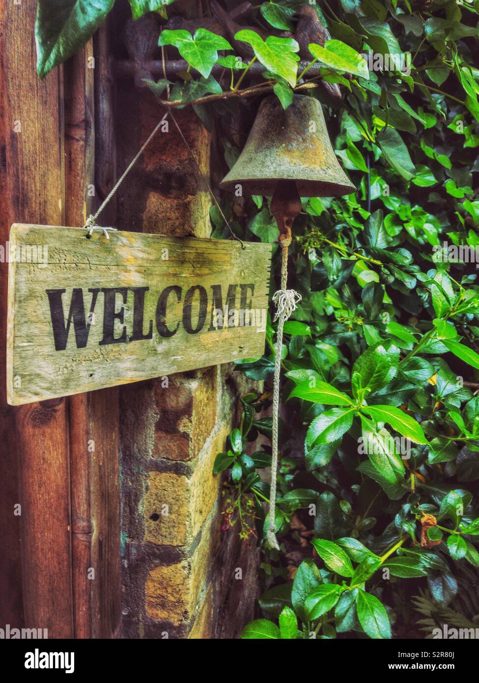 Bell with welcome sign outside a garden Stock Photo - Alamy