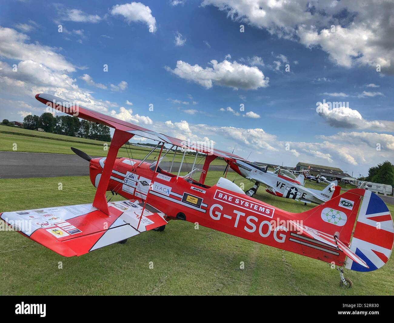 Red Biplane parked next to a T-51 Stock Photo - Alamy