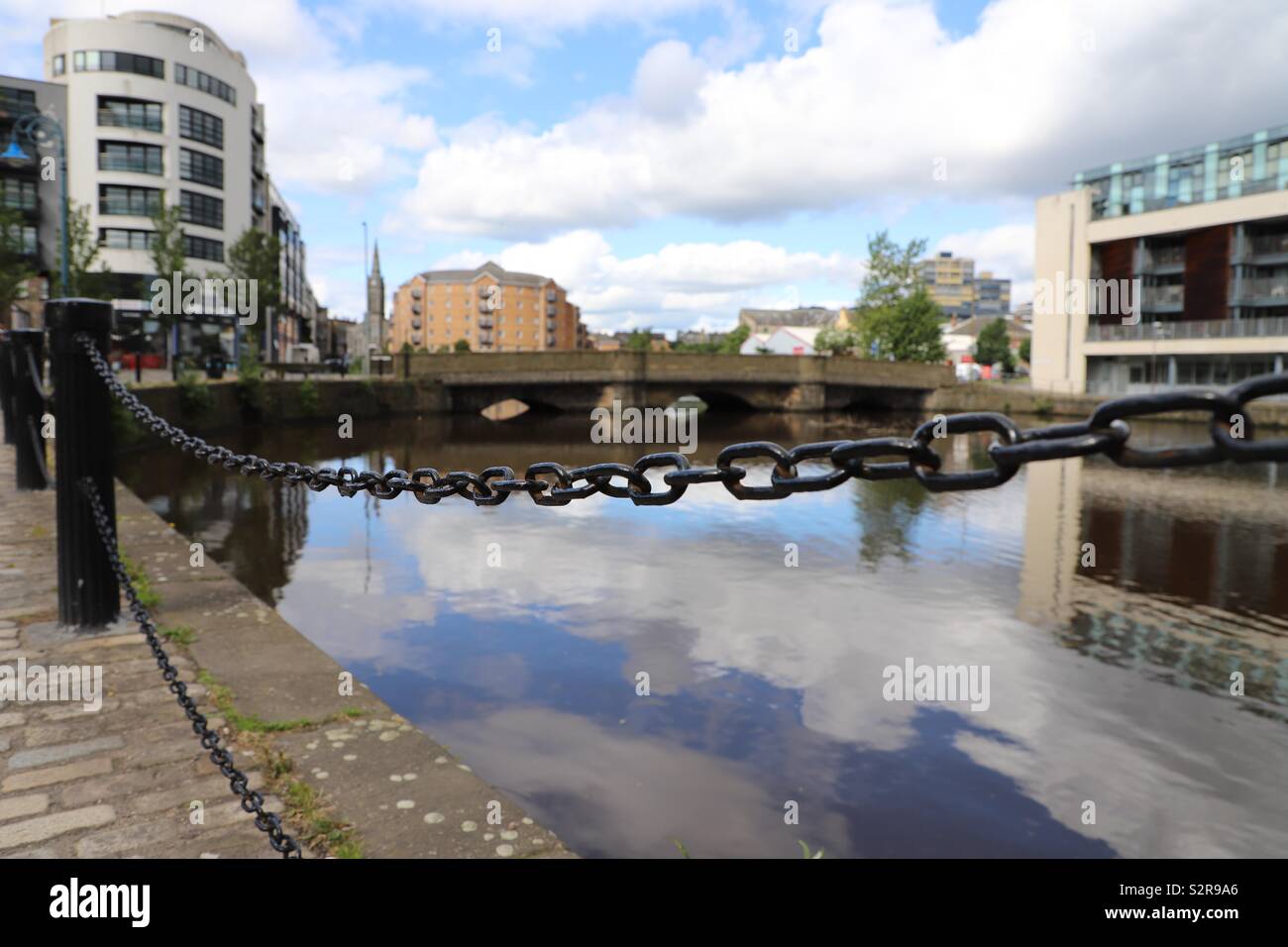Closeup image of chain link fence along river bank Stock Photo - Alamy