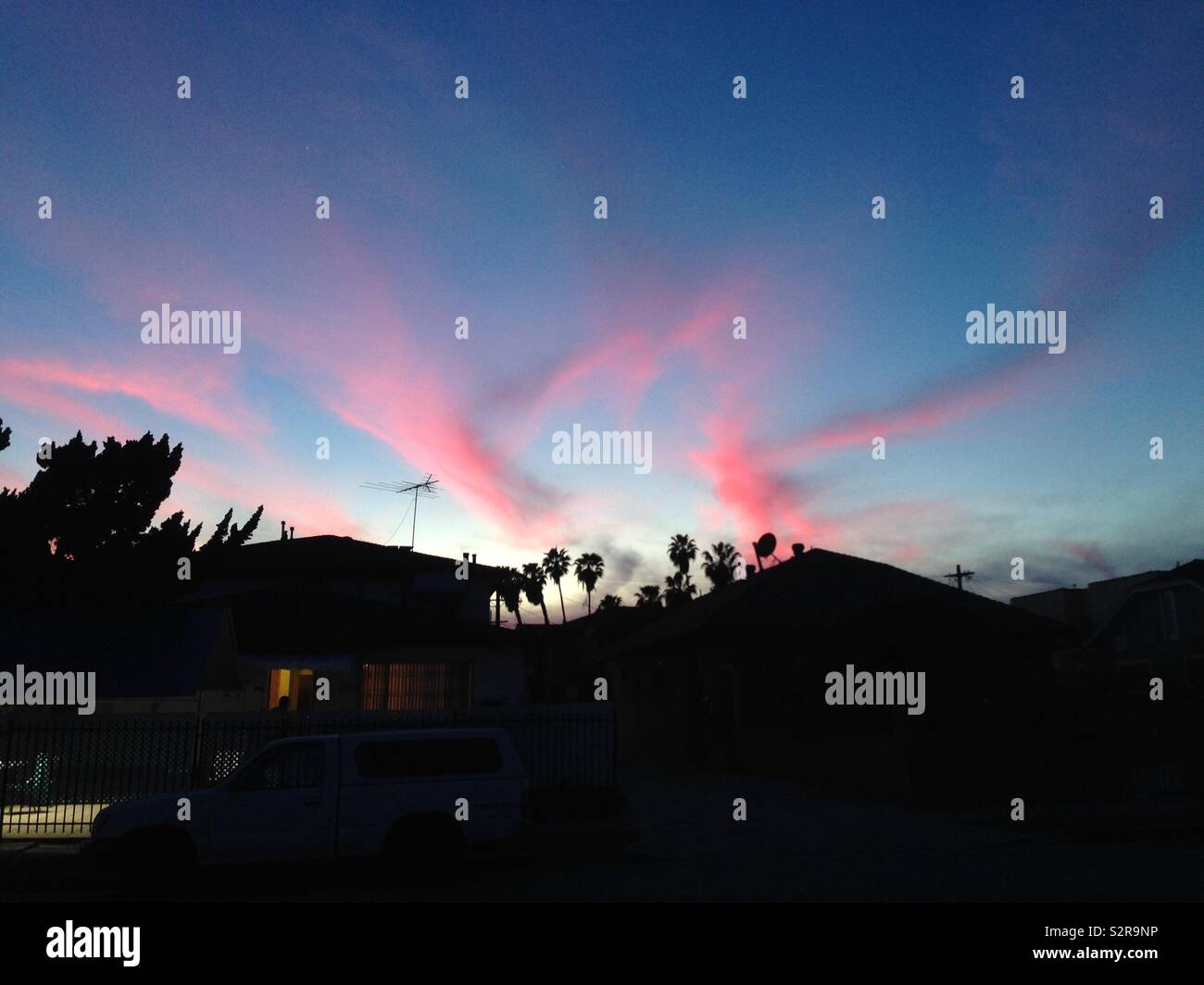 Blue and pink sunset over neighborhood Stock Photo - Alamy