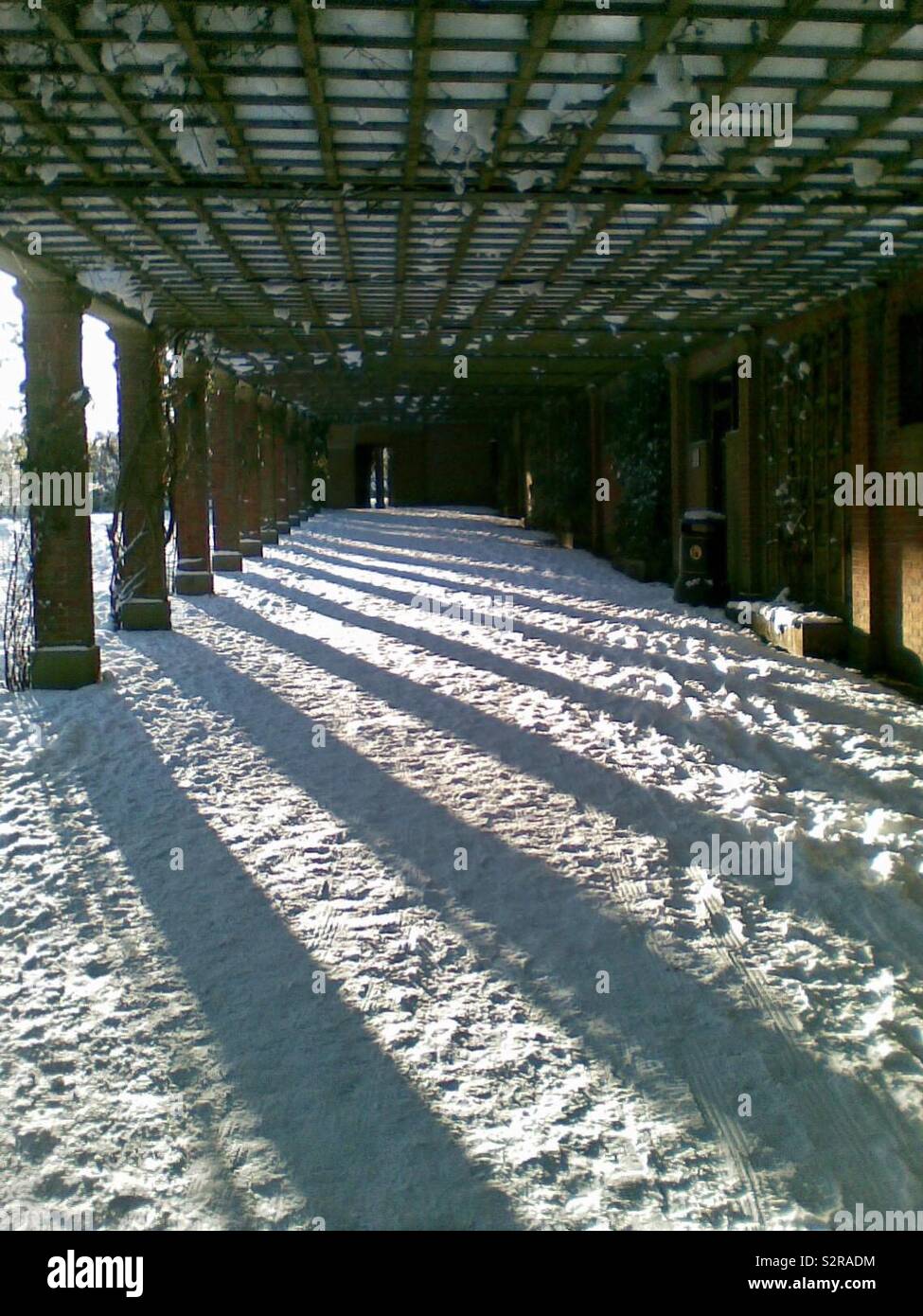 The afternoon sun casts dramatic shadows onto the snow in the pergola ...