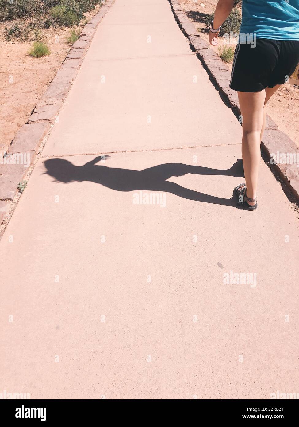 Shadow of a woman walking Stock Photo - Alamy