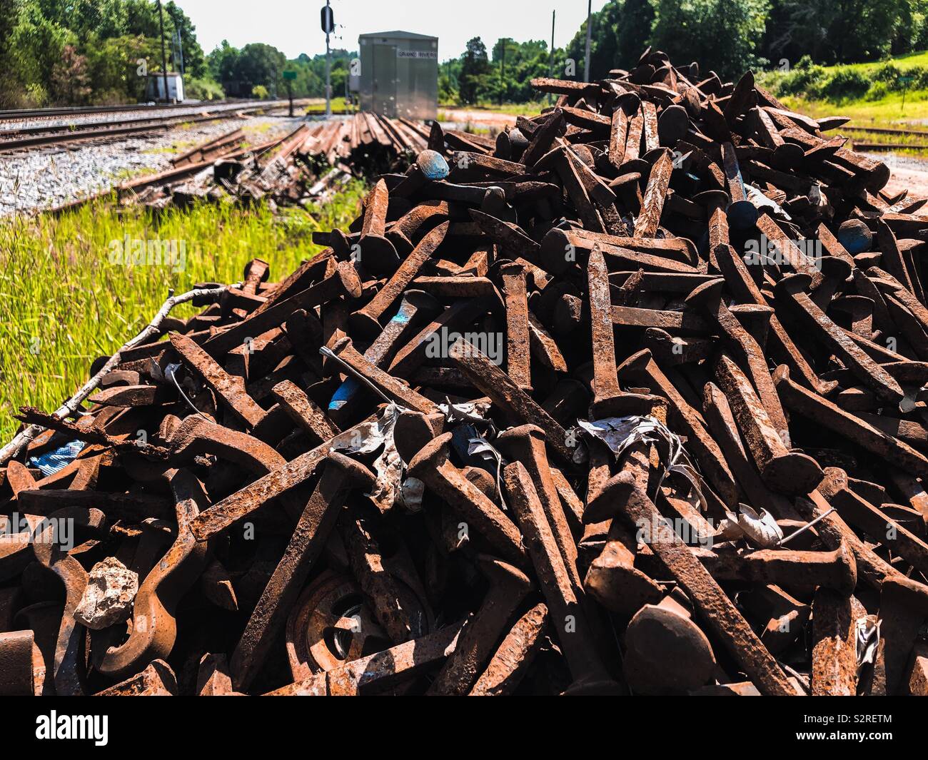 A stack of used, rusted railroad spikes and fasteners awaiting ...