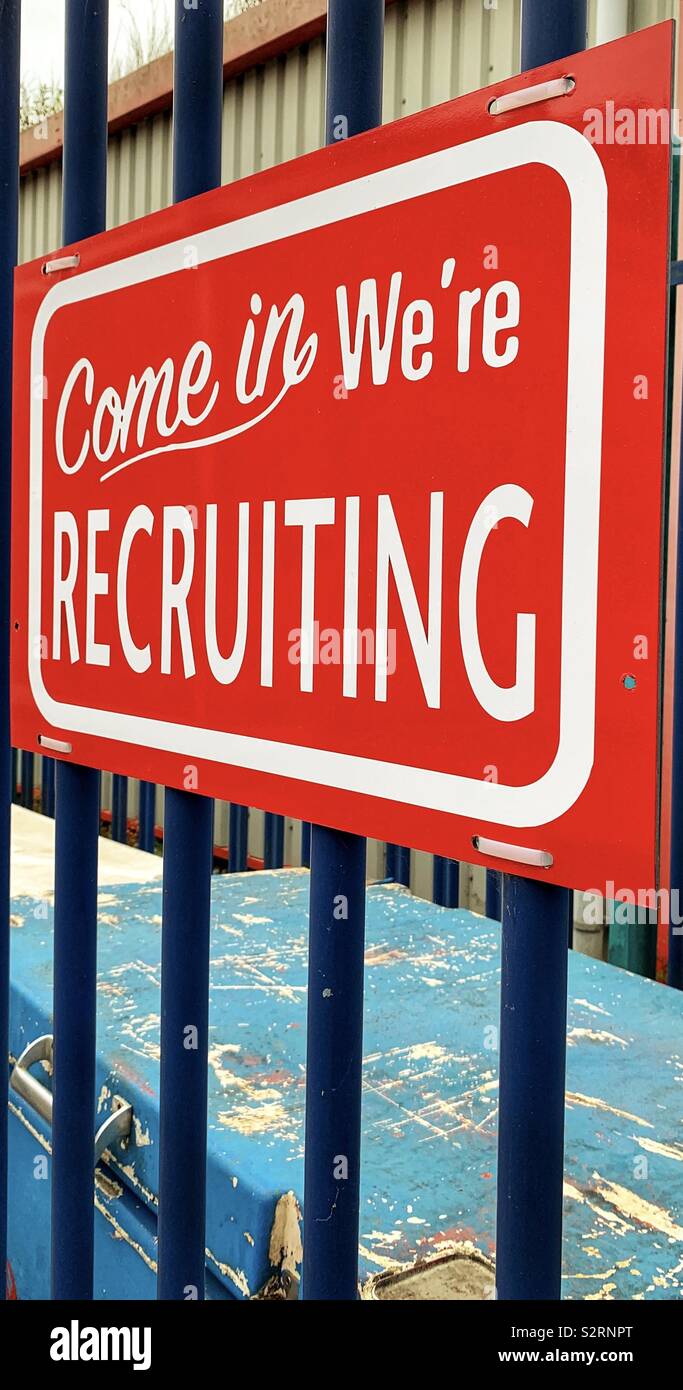 Red and white recruitment sign on blue metal gate Stock Photo - Alamy
