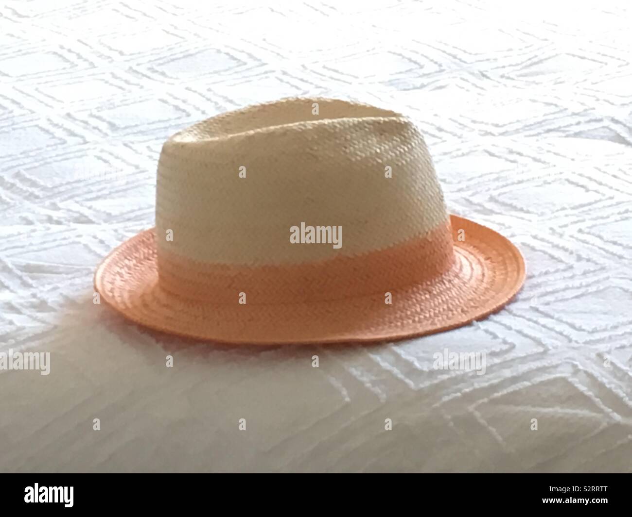 Straw hat on top of bed Stock Photo - Alamy