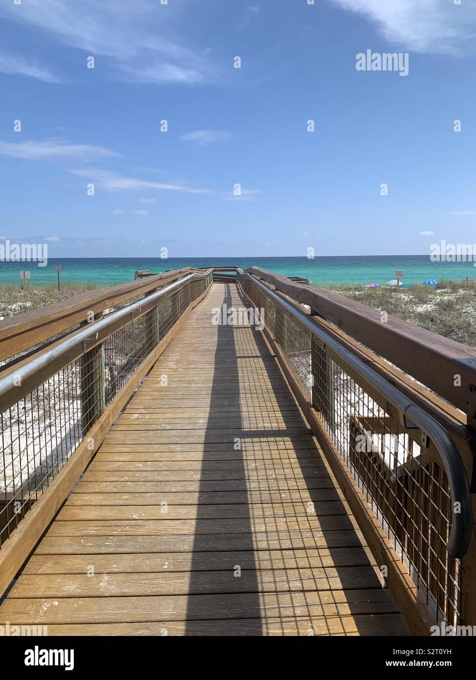 Wooden bridge walkway to the beach with scenic view of beautiful ...