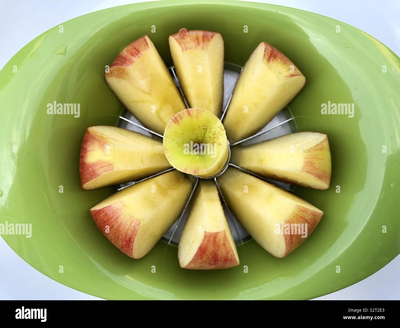 Apple cut into segments by slicer Stock Photo - Alamy