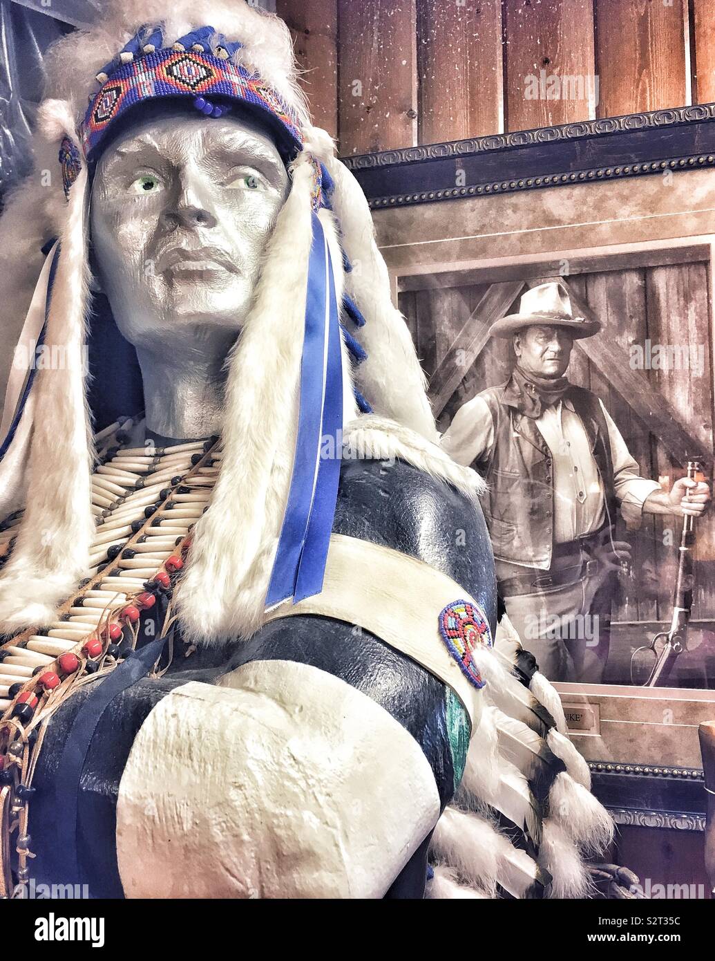 Statue of Native American with his arms folded and back turned towards ...